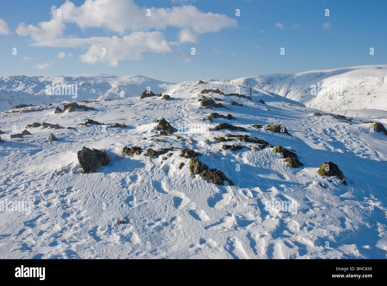 The Cumbrian Lake District fells covered in snow with blue sky and ...