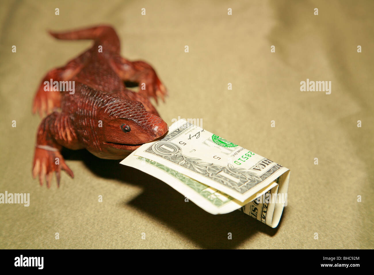 Wooden komodo dragon lizard souvenir carving biting US dollar bill ...
