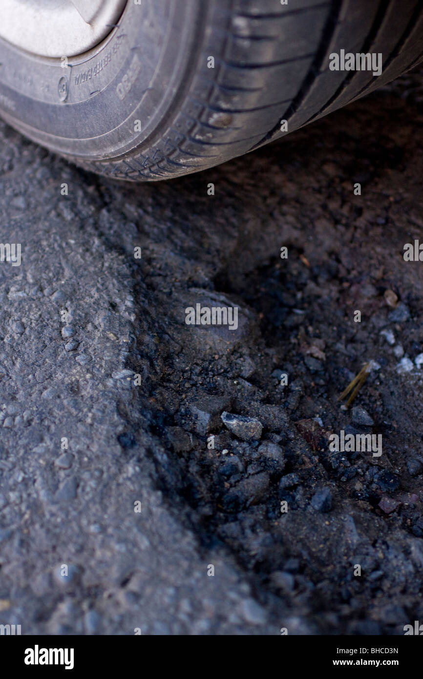 Close up of a pot hole with car wheel on edge of it Stock Photo - Alamy