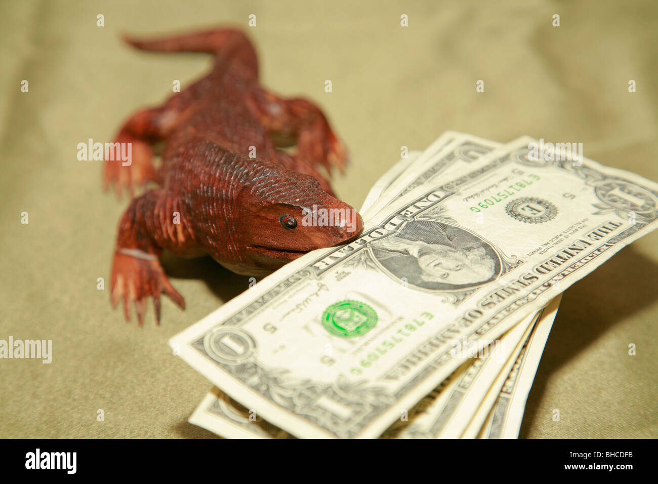 Wooden komodo dragon lizard souvenir carving biting US dollar bills ...
