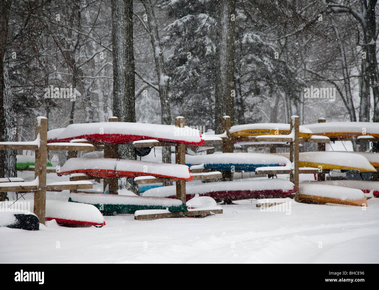 Canoes and kayaks on a rack during a snowstorm Stock Photo - Alamy