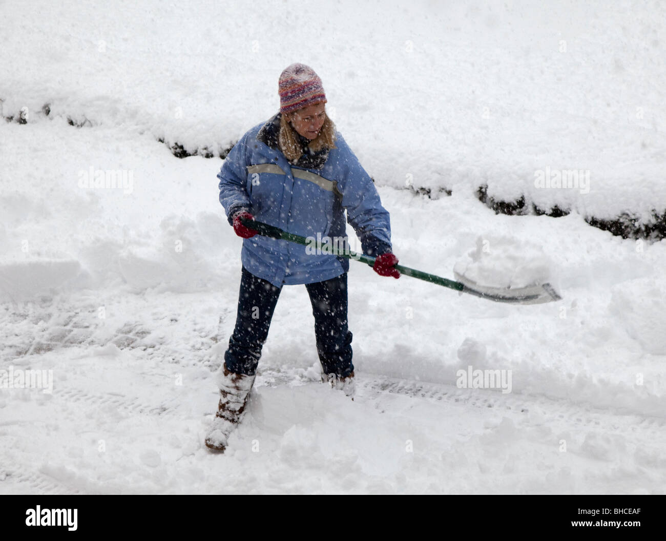 Woman shoveling snow Stock Photo - Alamy