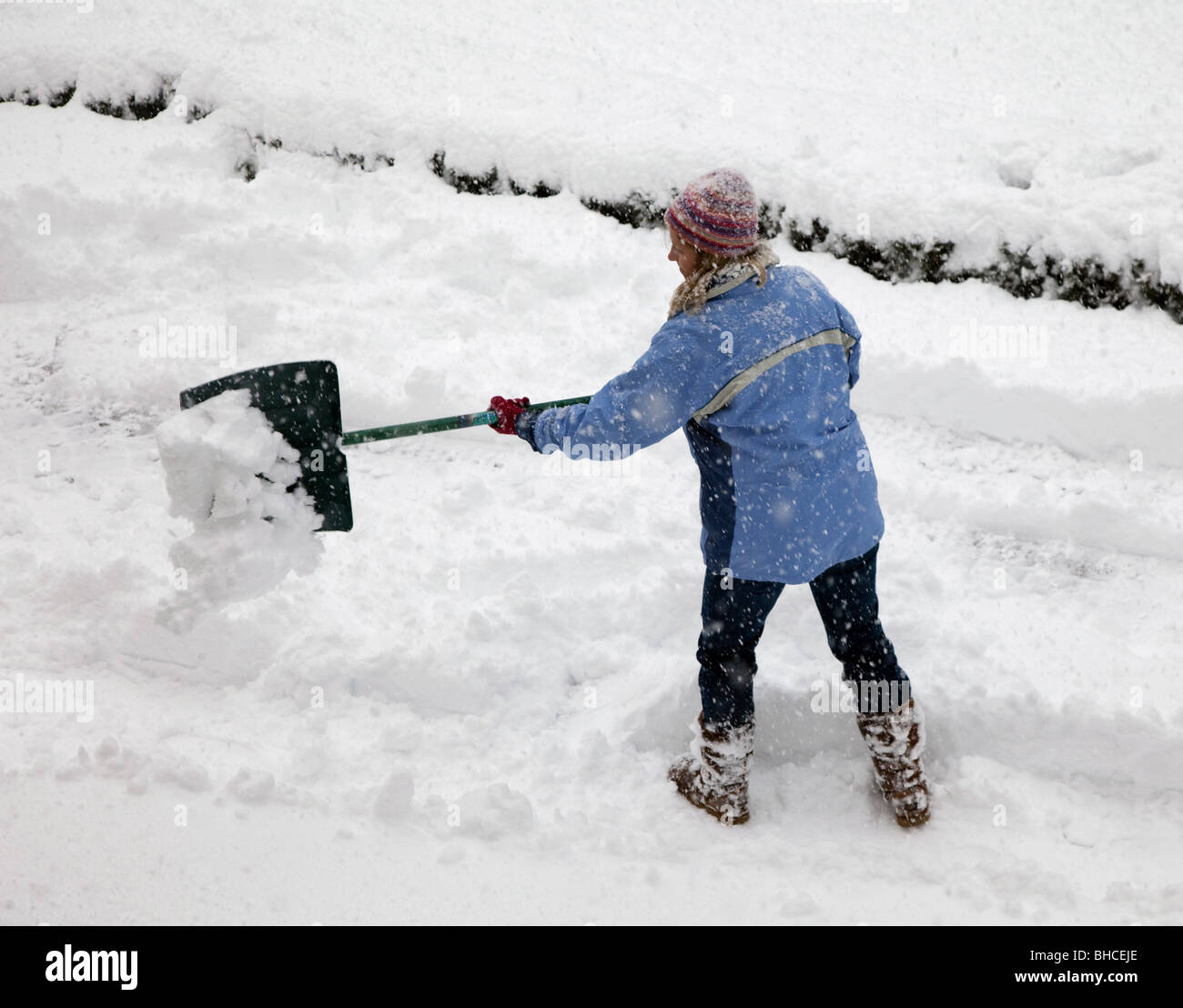 Woman shoveling snow Stock Photo - Alamy