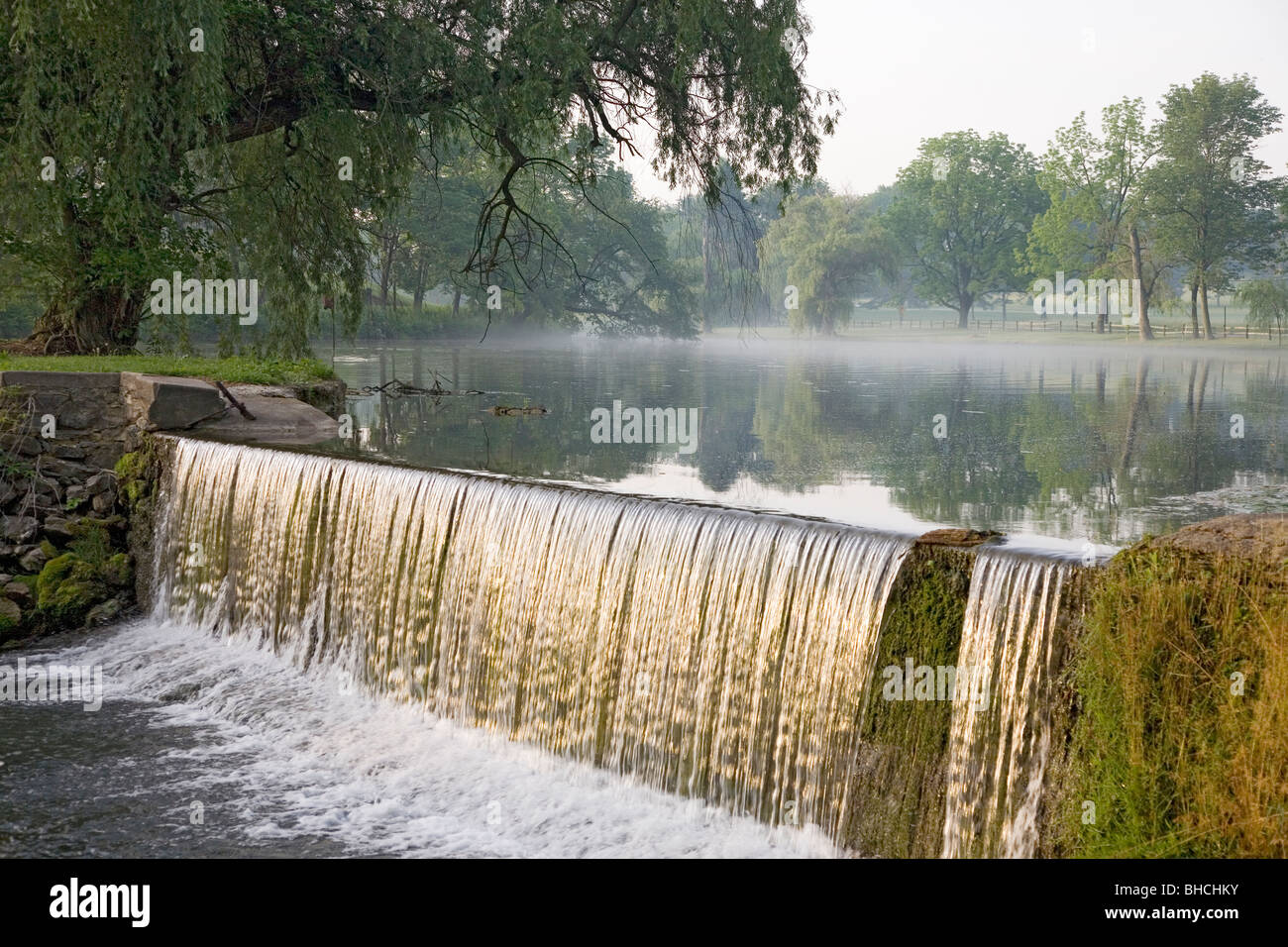 Waterfall, pond and mist in early morning in the surrounding ...