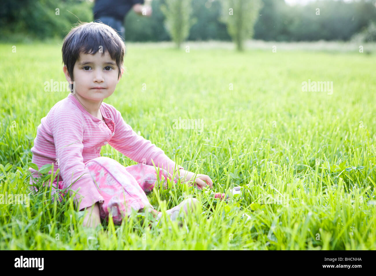 Girl sitting in grass Stock Photo - Alamy