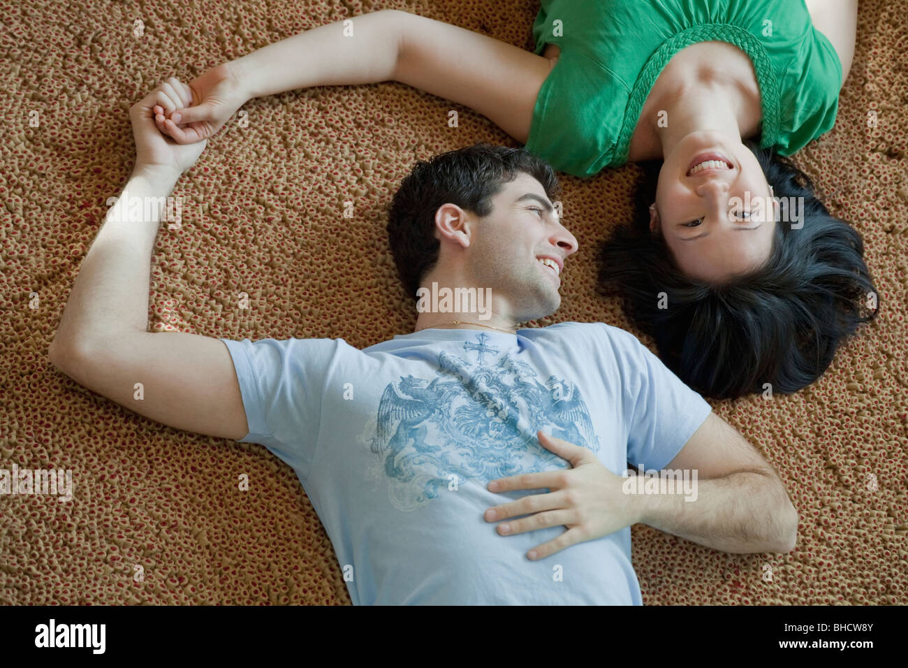 Couple laying on floor holding hands Stock Photo - Alamy