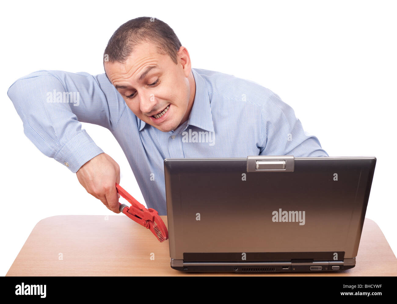 Clueless businessman trying to fix his computer with a plier Stock ...