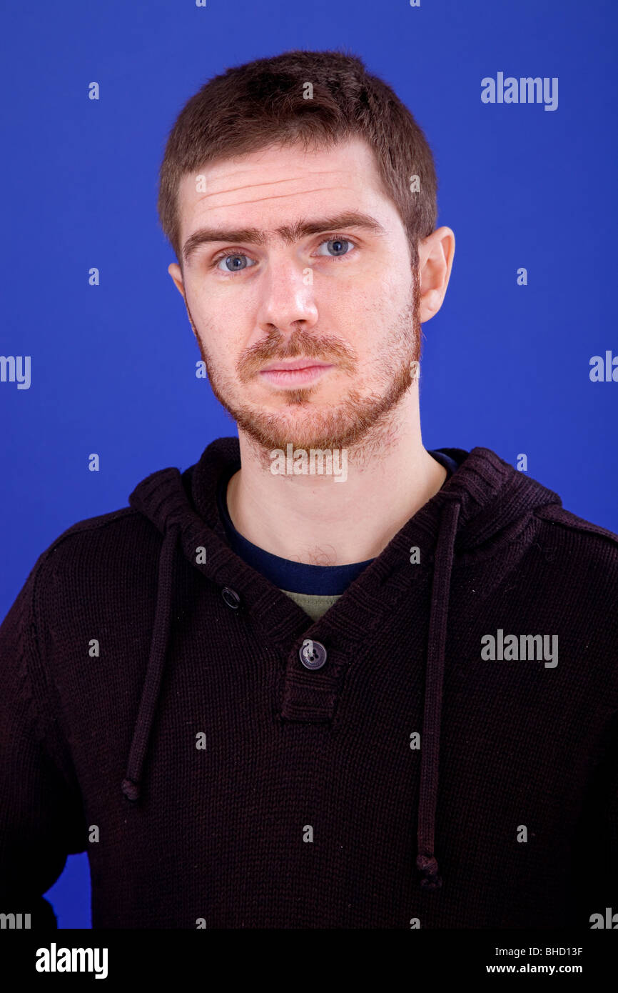 an young man portrait over a blue background Stock Photo - Alamy