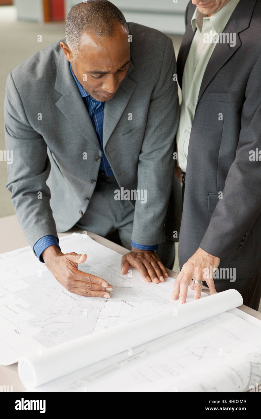 Businessmen looking at blueprints Stock Photo - Alamy