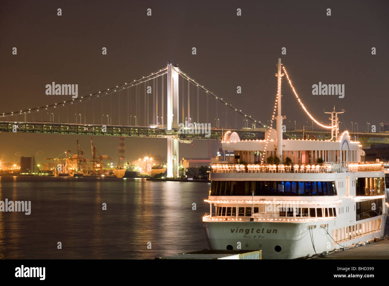 Ferry docked in harbor with Rainbow Bridge in background. Minato-ku ...