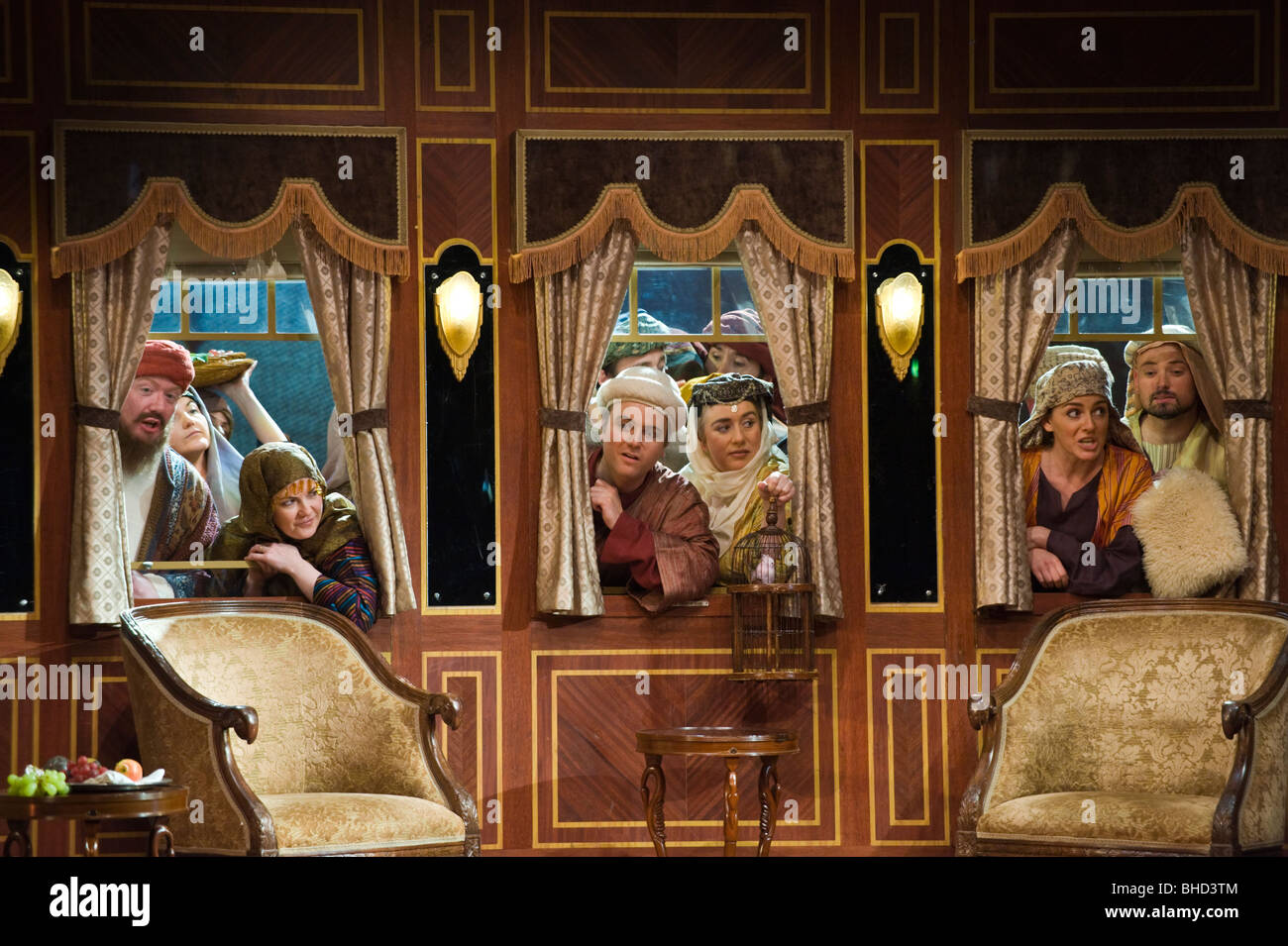 The Welsh National Opera chorus peer through windows in a production of ...