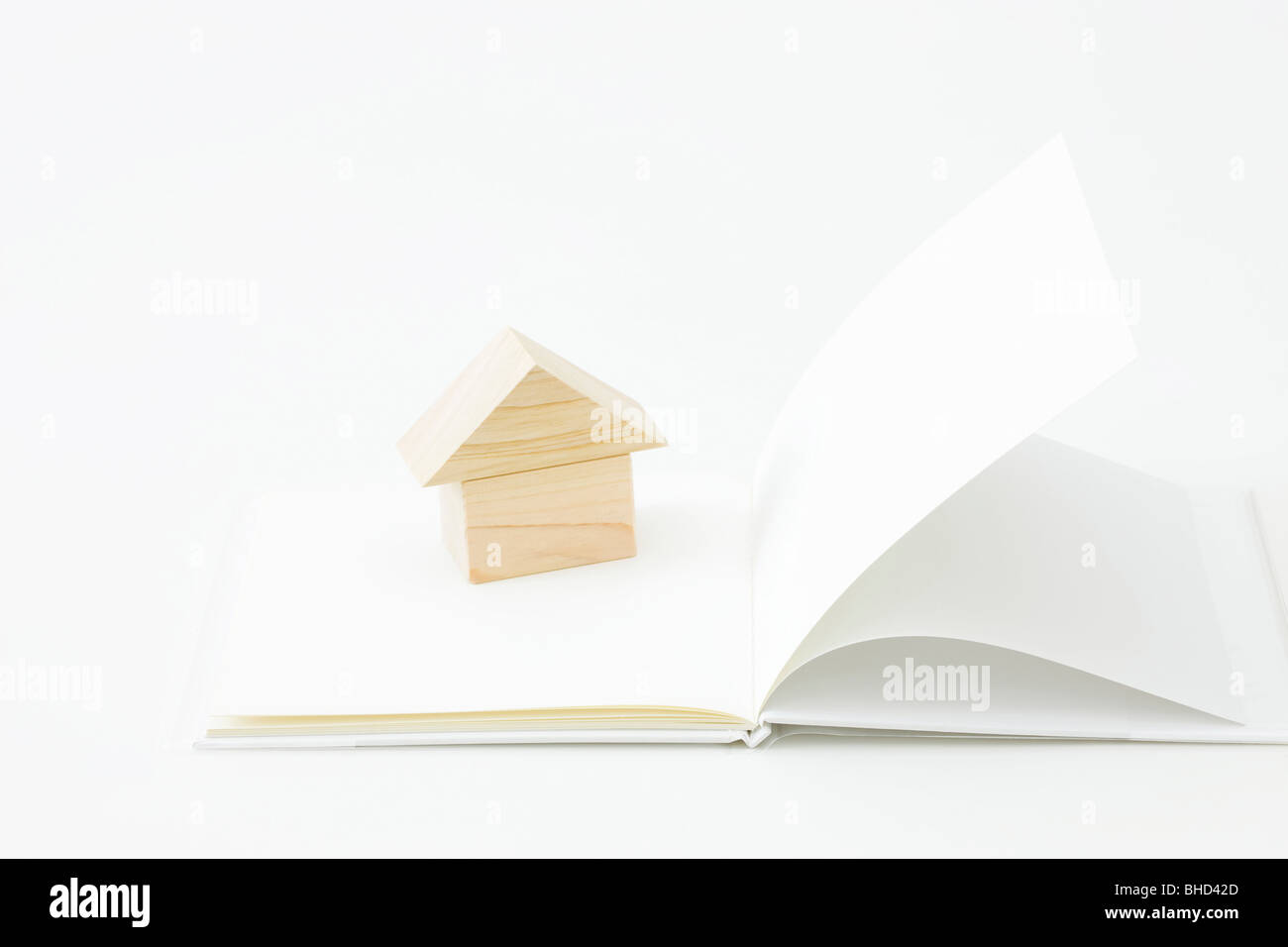Wooden block house on blank book Stock Photo - Alamy