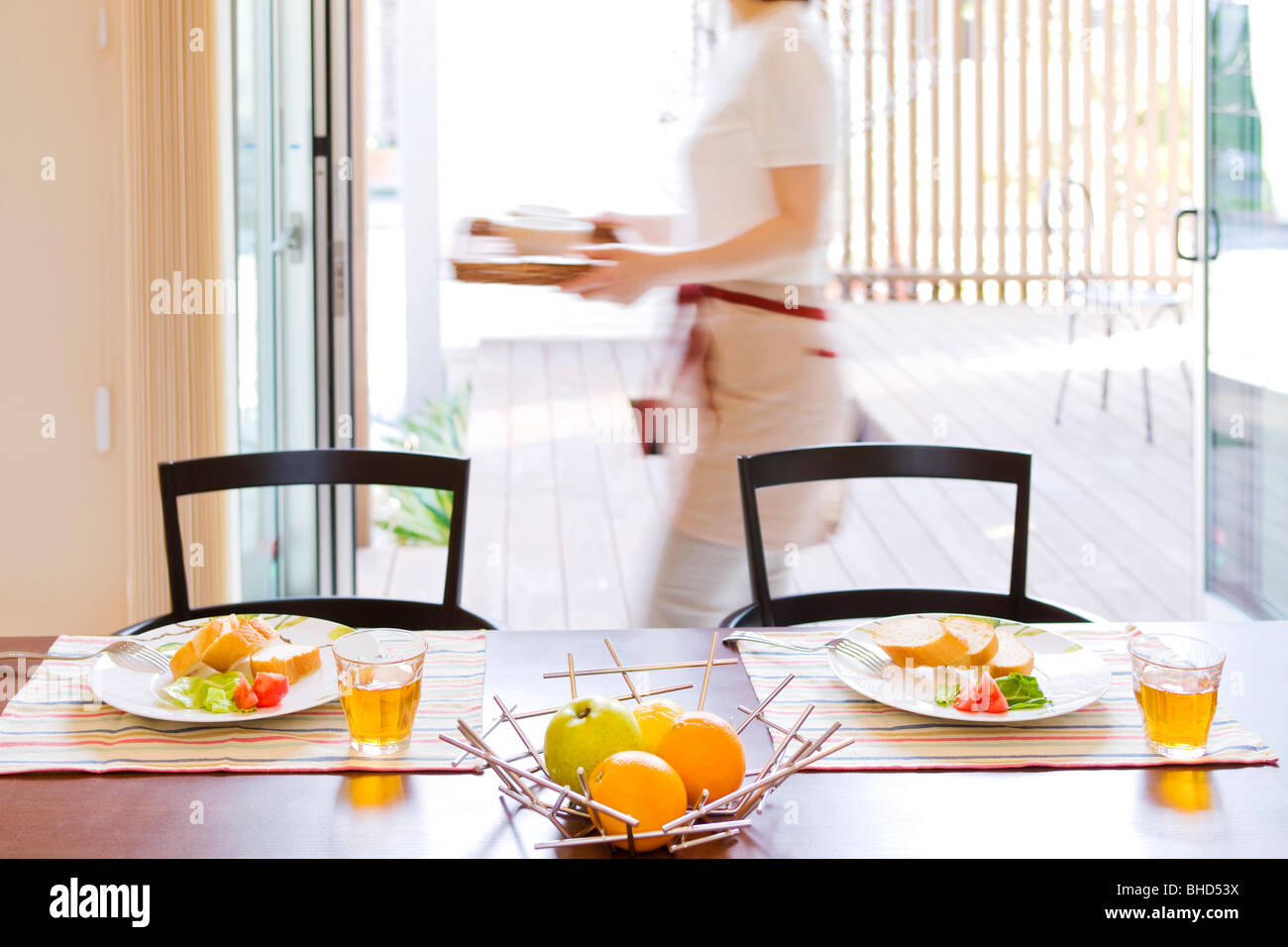 Woman walking in dining room Stock Photo - Alamy
