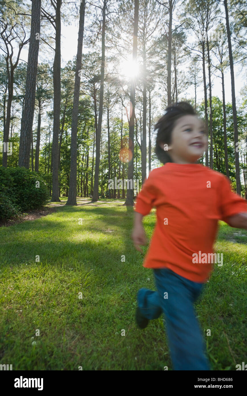 Hispanic boy running in forest Stock Photo - Alamy