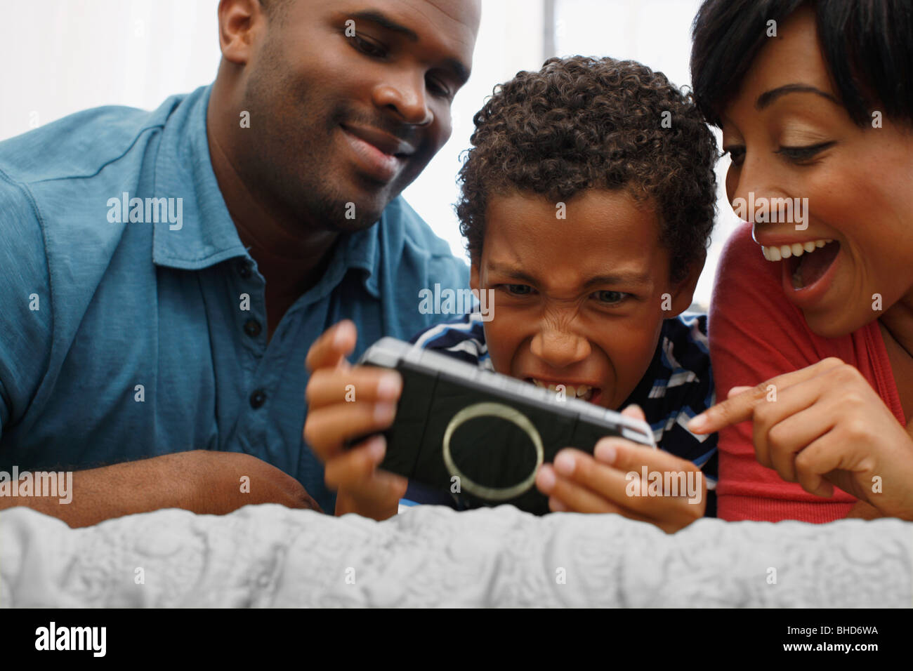 Parents watching son play video game Stock Photo - Alamy