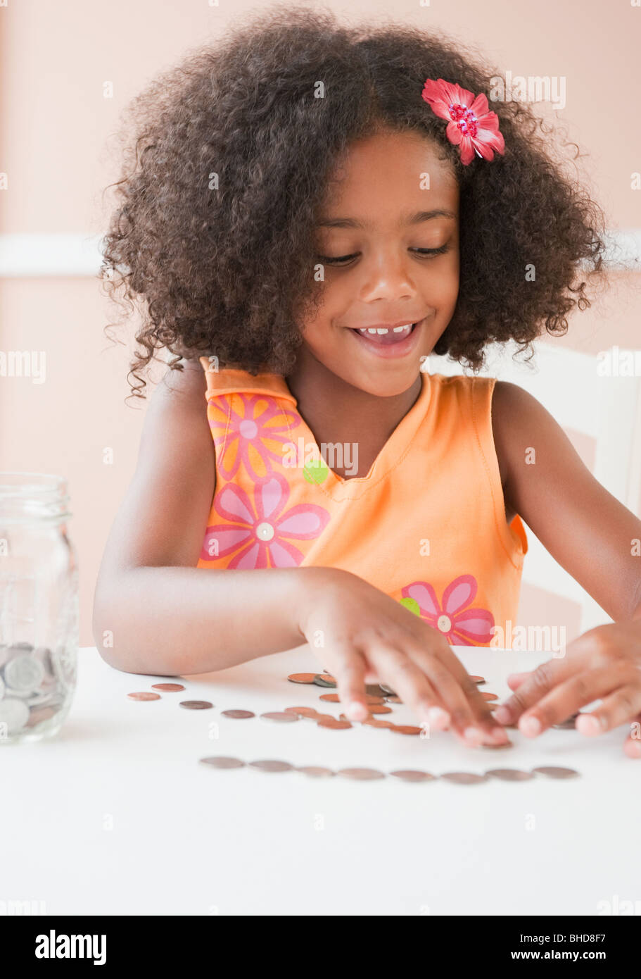 Mixed race girl counting coins Stock Photo - Alamy