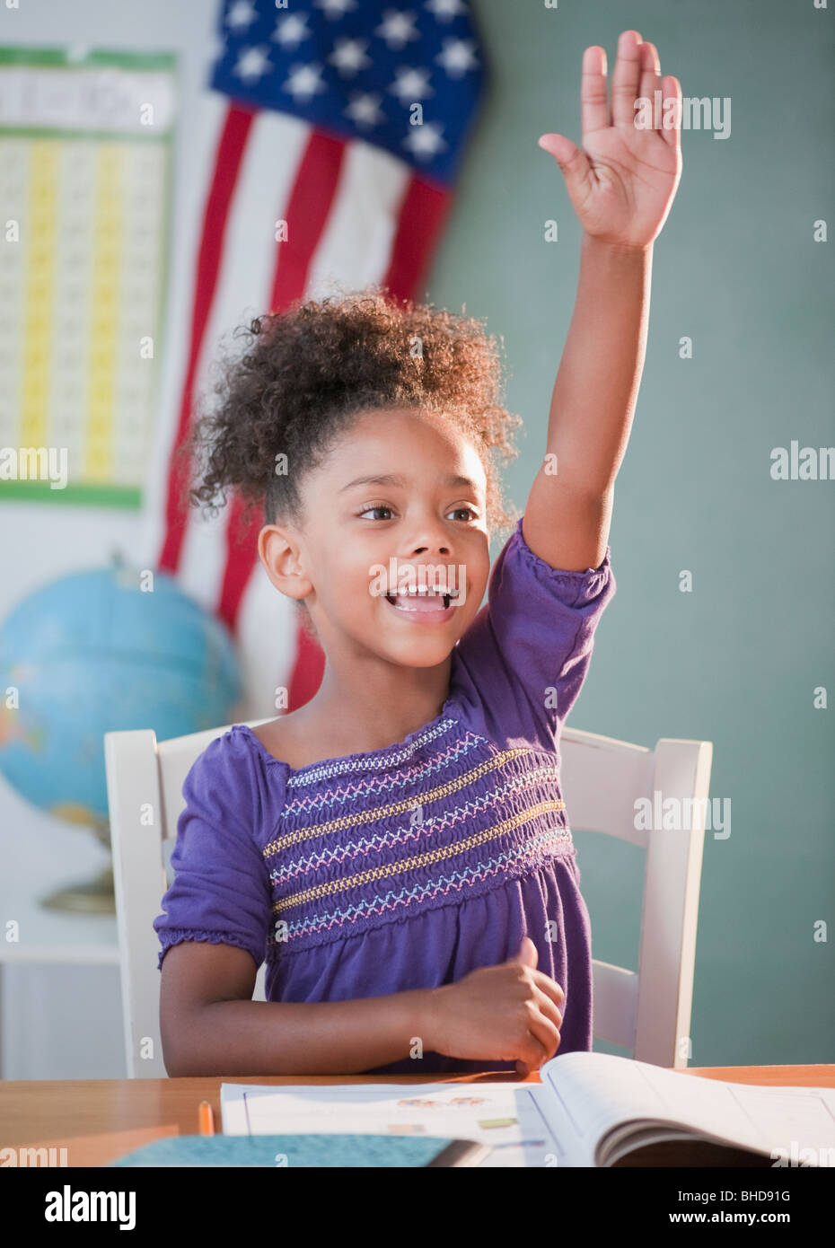 Mixed race girl answering question in classroom Stock Photo - Alamy