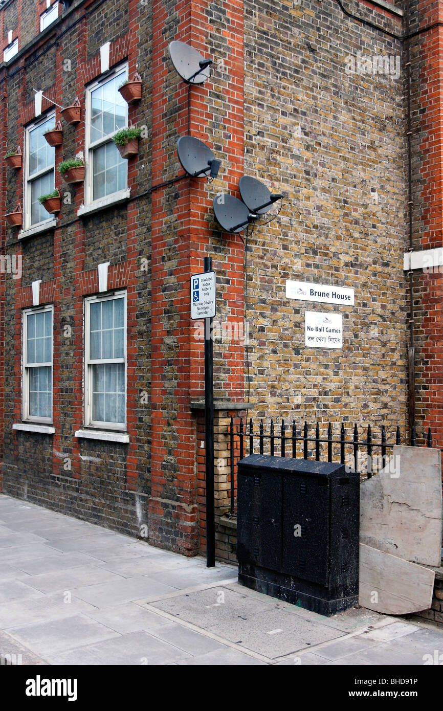 a house in east london covered in satellite dishes and flower pots ...