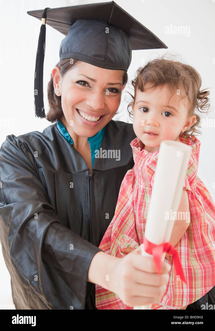 Hispanic mother graduate holding daughter and diploma Stock Photo - Alamy
