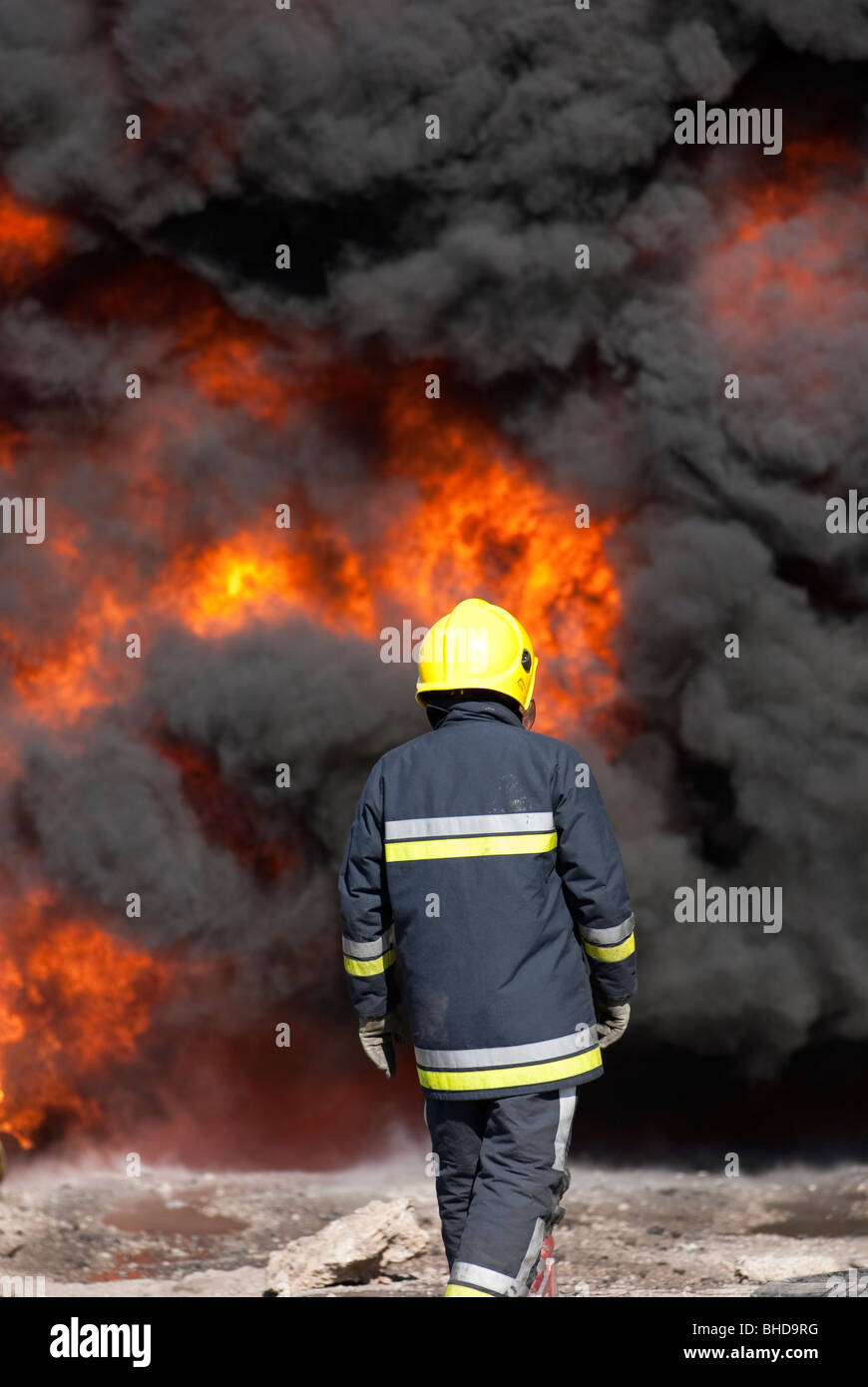 Fireman in front of thick black smoke plume and fire Stock Photo - Alamy