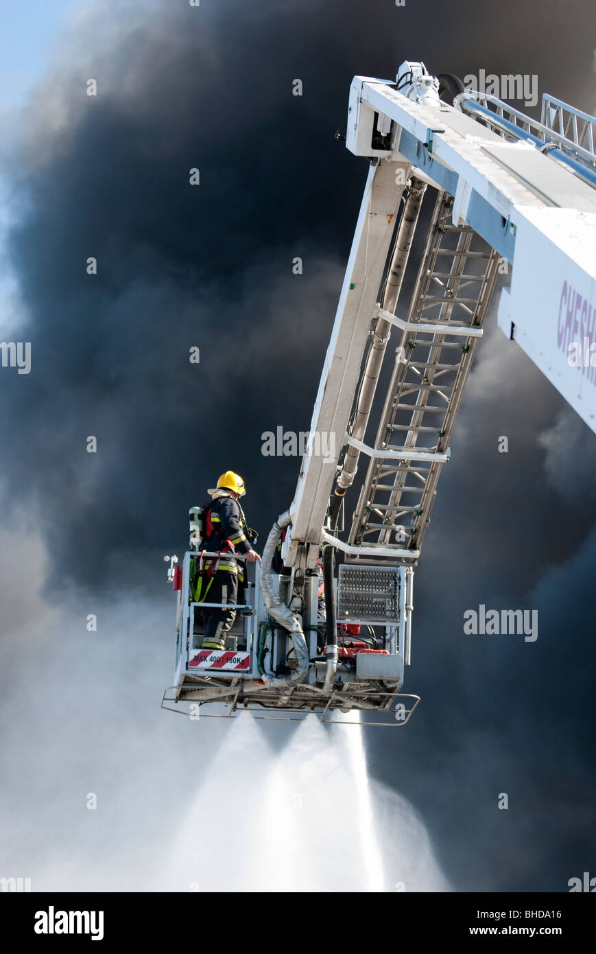 Firemen in cage of Hydraulic Platform with smoke behind Stock Photo - Alamy