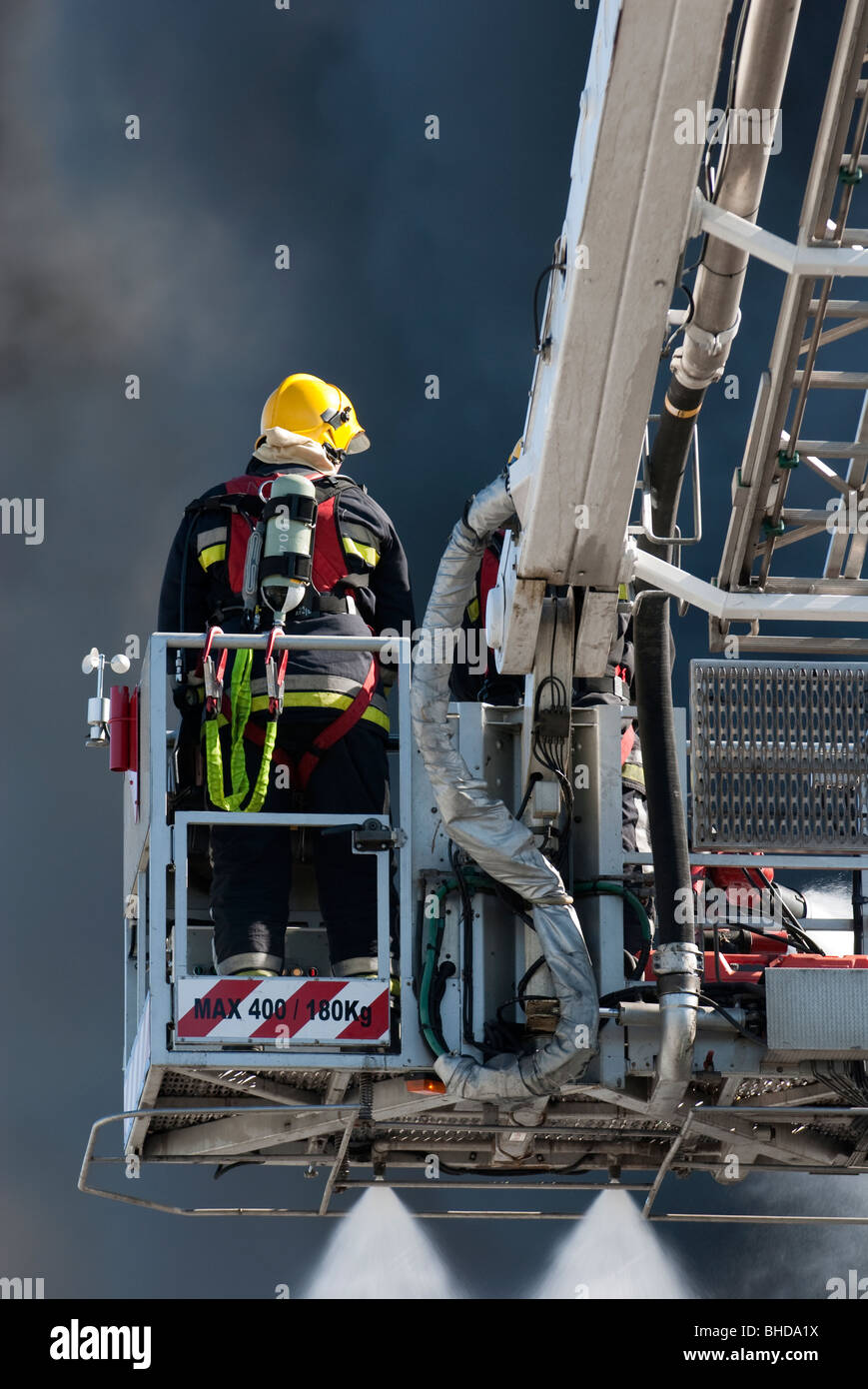 Firemen in cage of Hydraulic Platform with smoke behind Stock Photo - Alamy