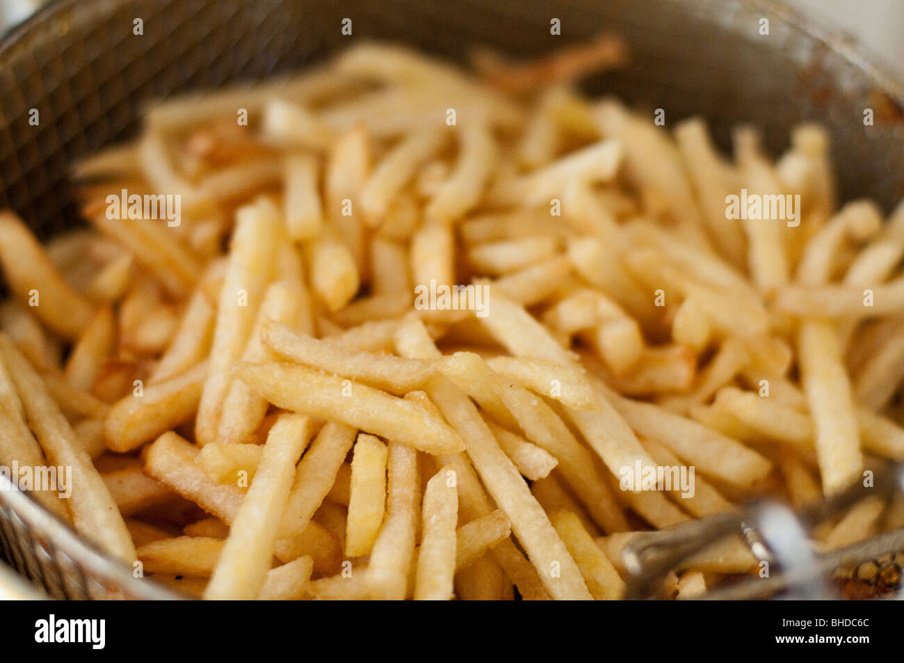 French fries over a deep fat fryer Stock Photo - Alamy