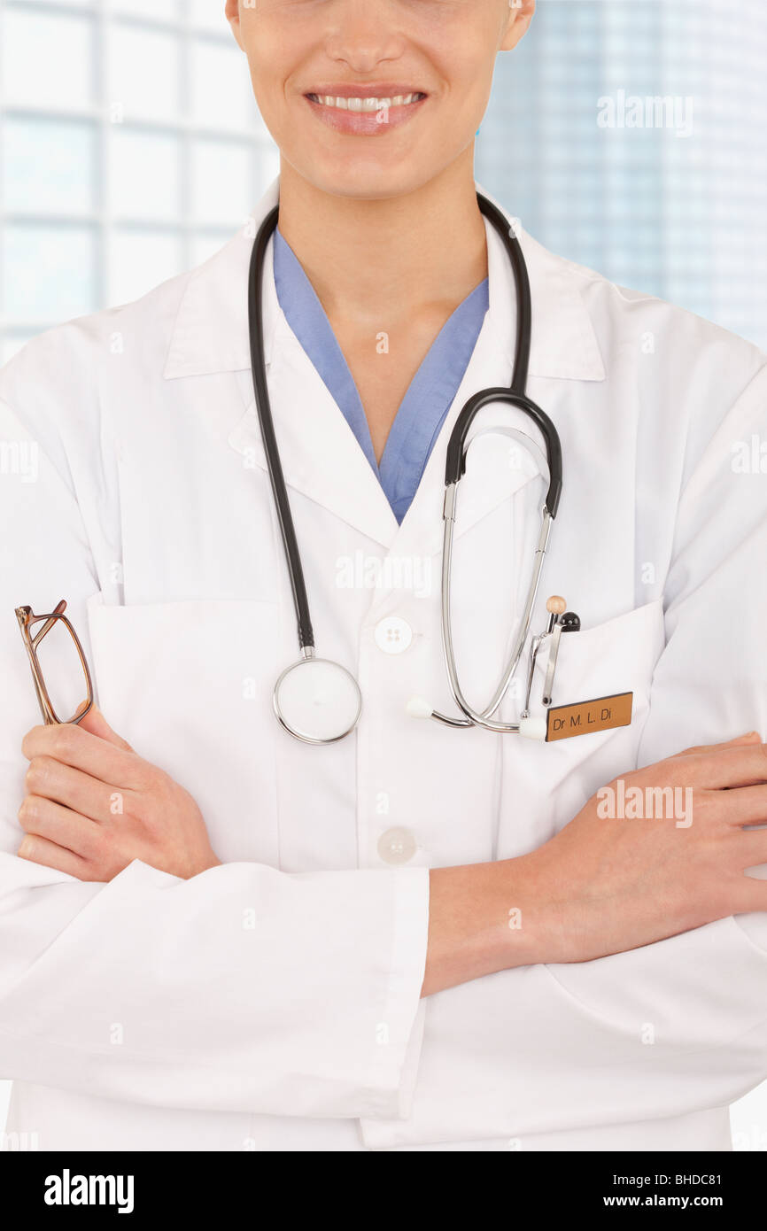Mixed race doctor with arms crossed in hospital Stock Photo - Alamy