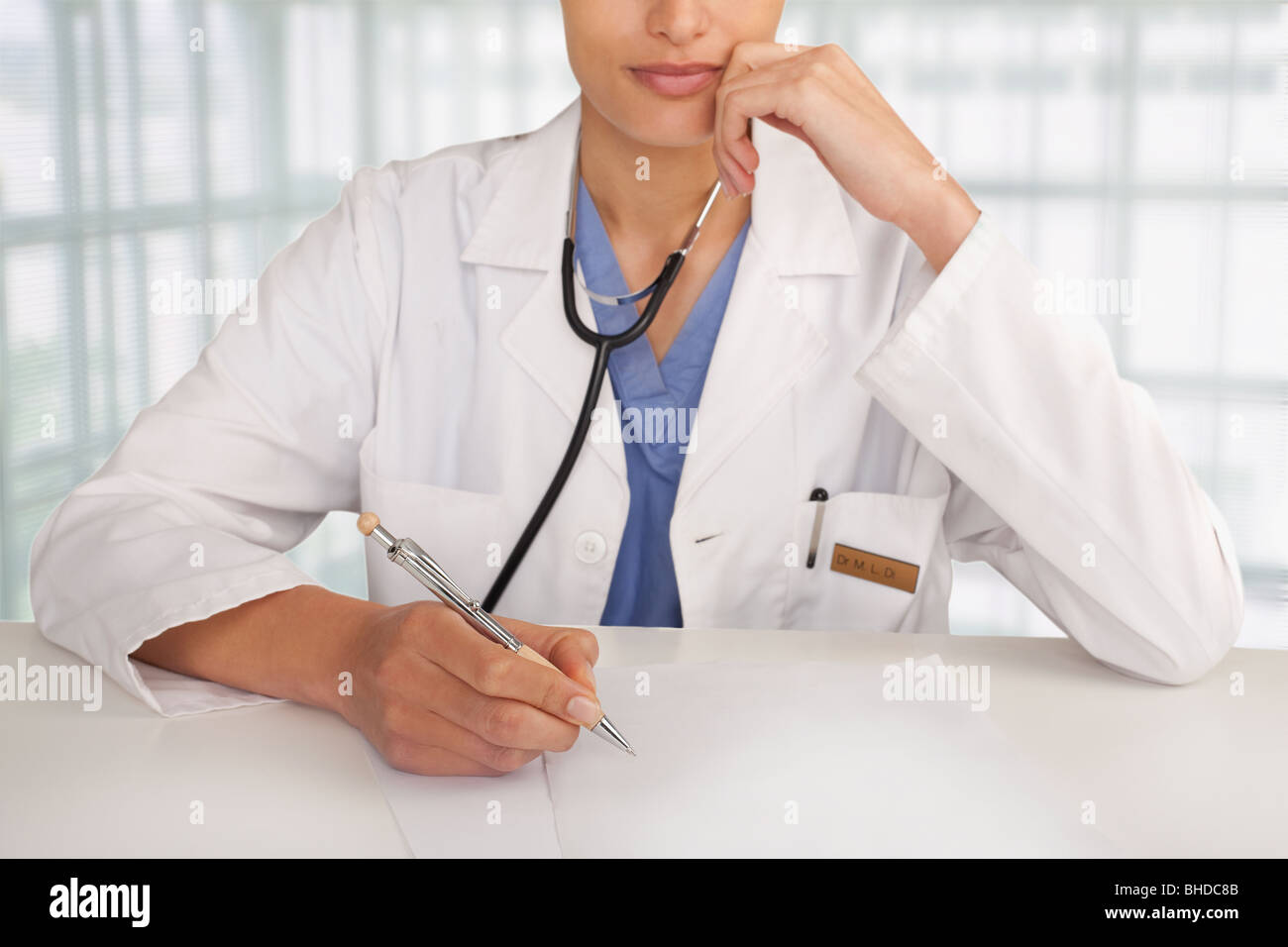 Mixed race doctor writing in hospital Stock Photo - Alamy