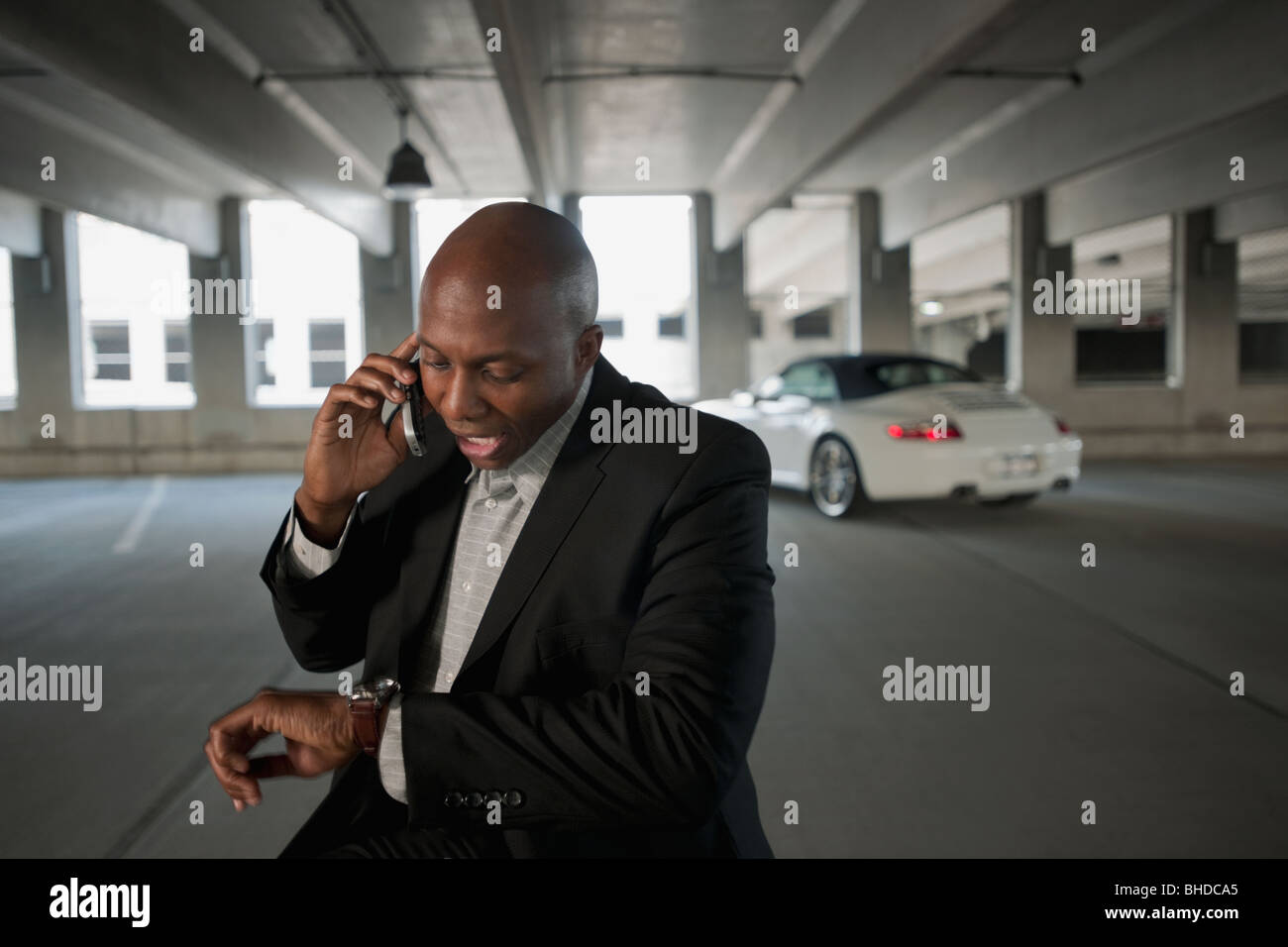 African businessman talking on cell phone in parking garage Stock Photo ...