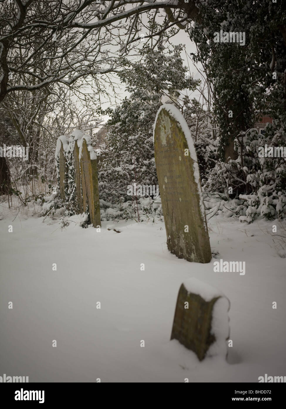 A tombstone in a graveyard covered in snow Stock Photo - Alamy