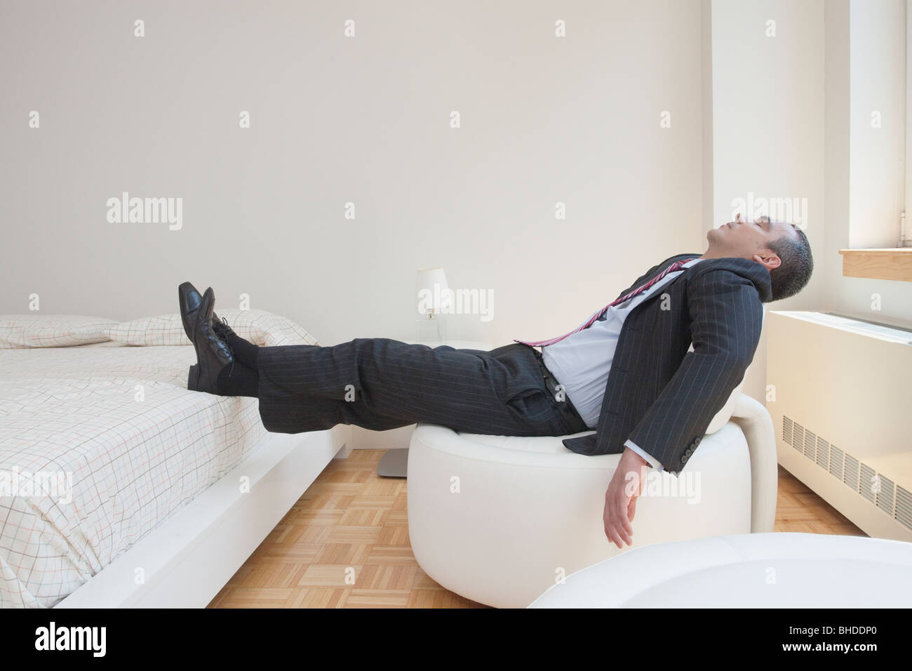 Hispanic businessman napping in chair Stock Photo - Alamy