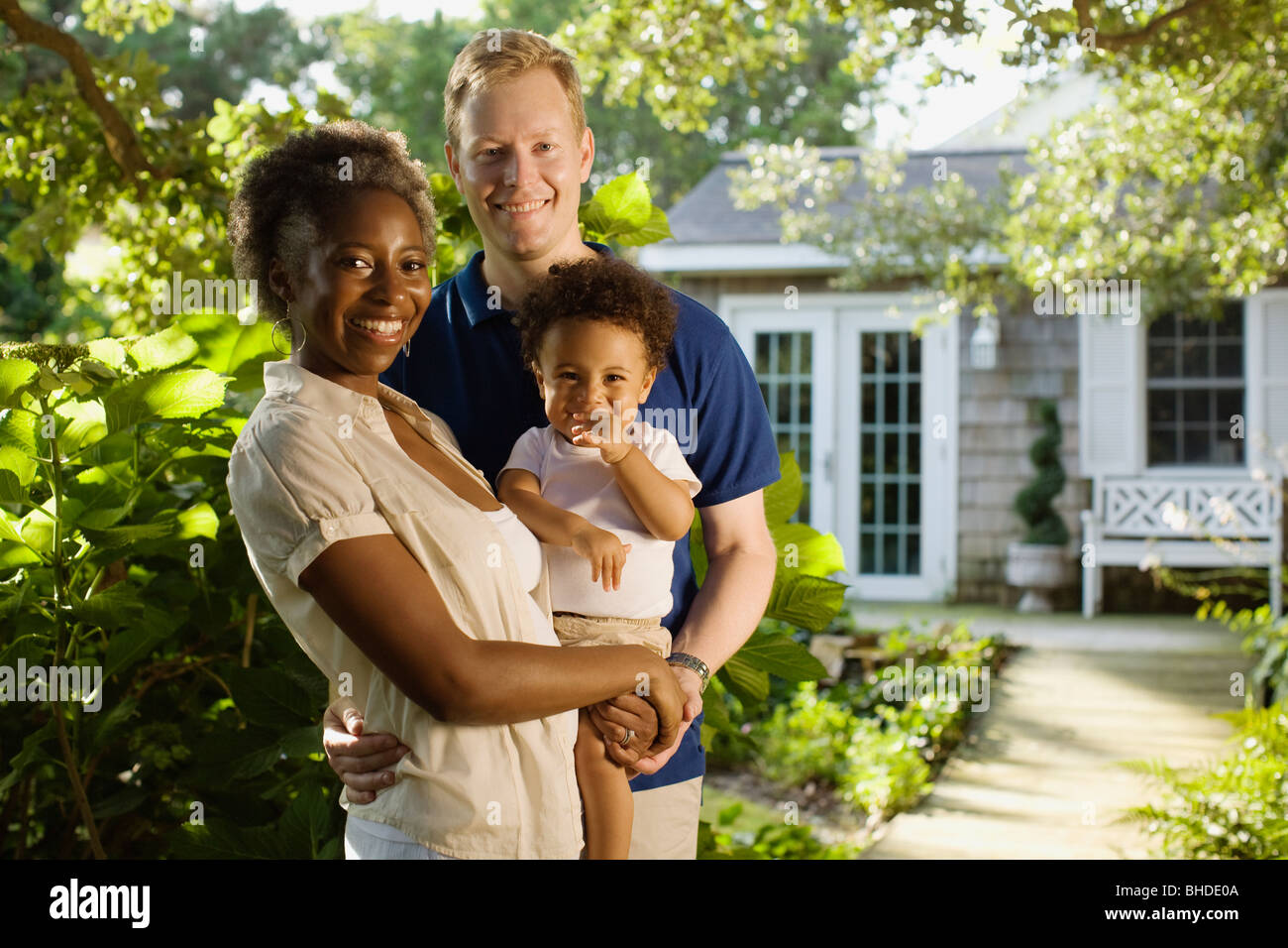 Multi-ethnic family smiling in garden Stock Photo - Alamy
