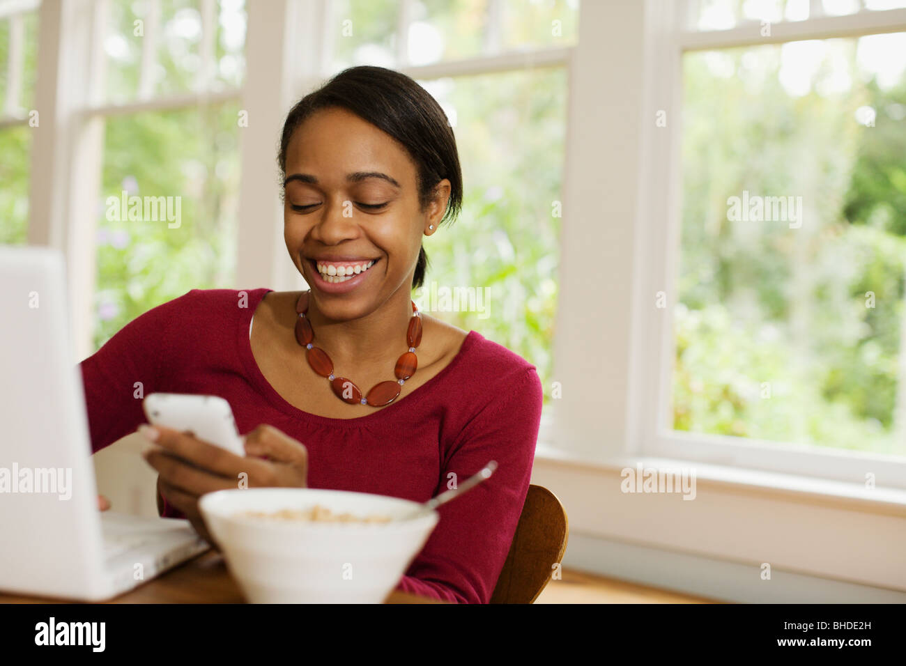 African woman reading text message at breakfast Stock Photo - Alamy