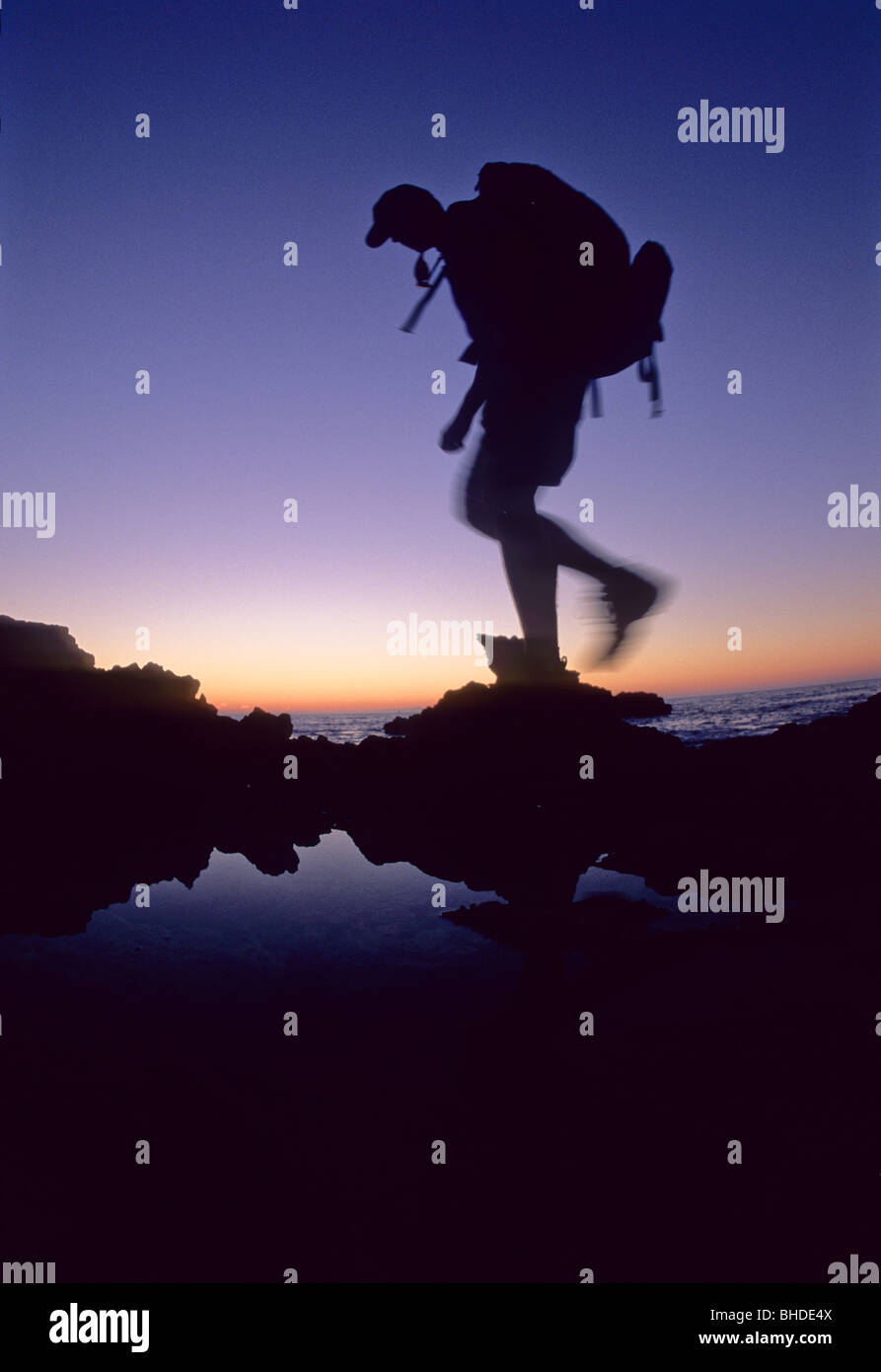 Man backpacking along coast Stock Photo - Alamy