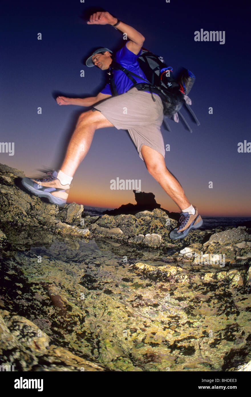 Man backpacking along coast Stock Photo - Alamy