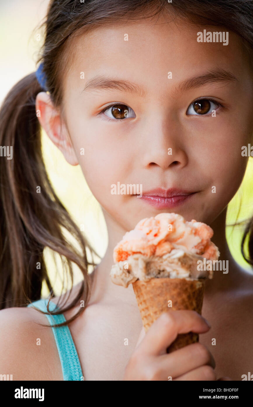 Mixed race girl eating ice cream cone Stock Photo - Alamy