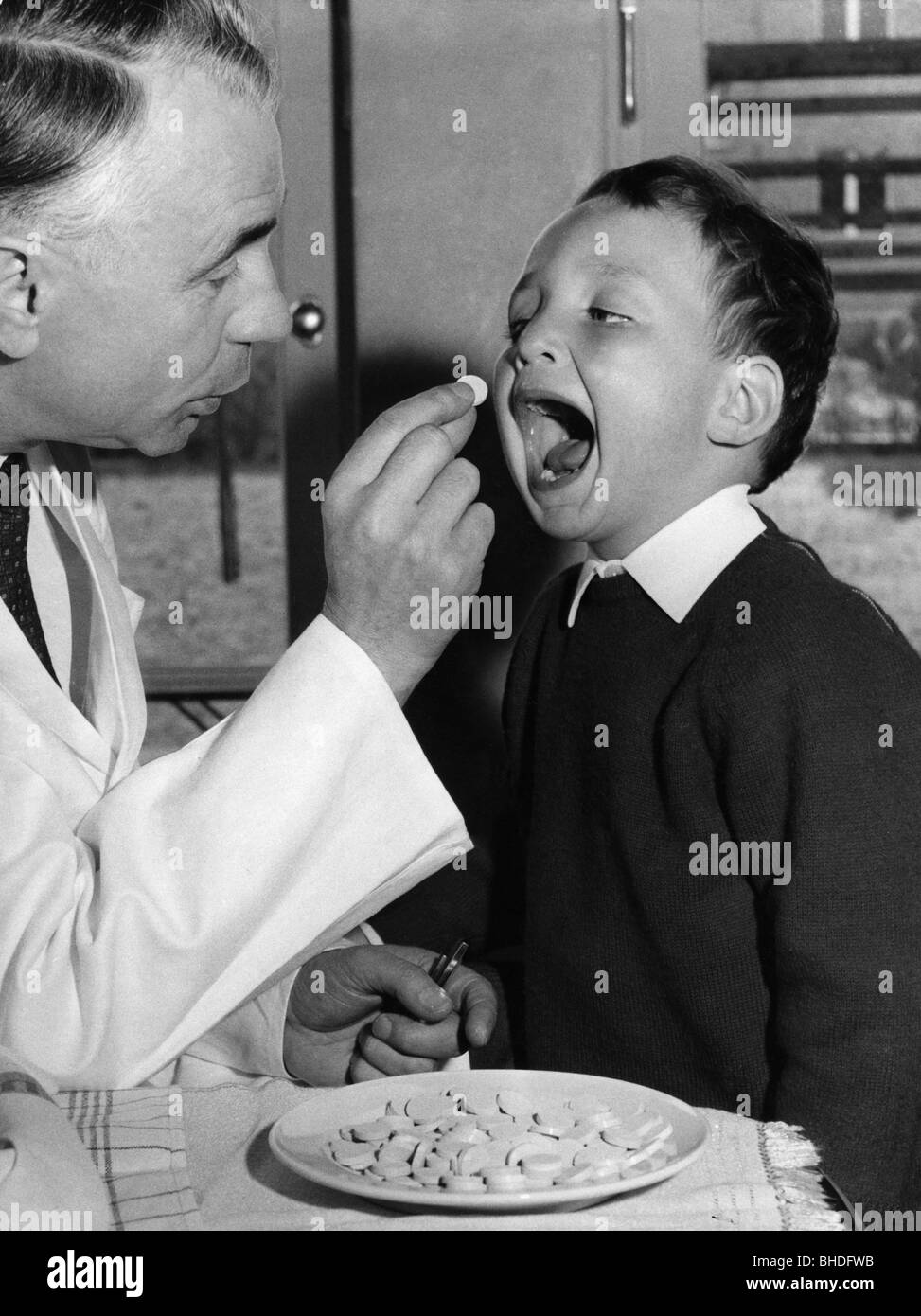 medicine, dentistry, medical doctor giving little boy fluorine tablet ...