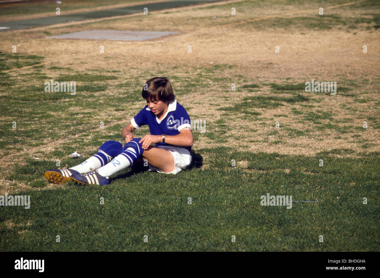 boy puts on protective gear before soccer football game health safe ...