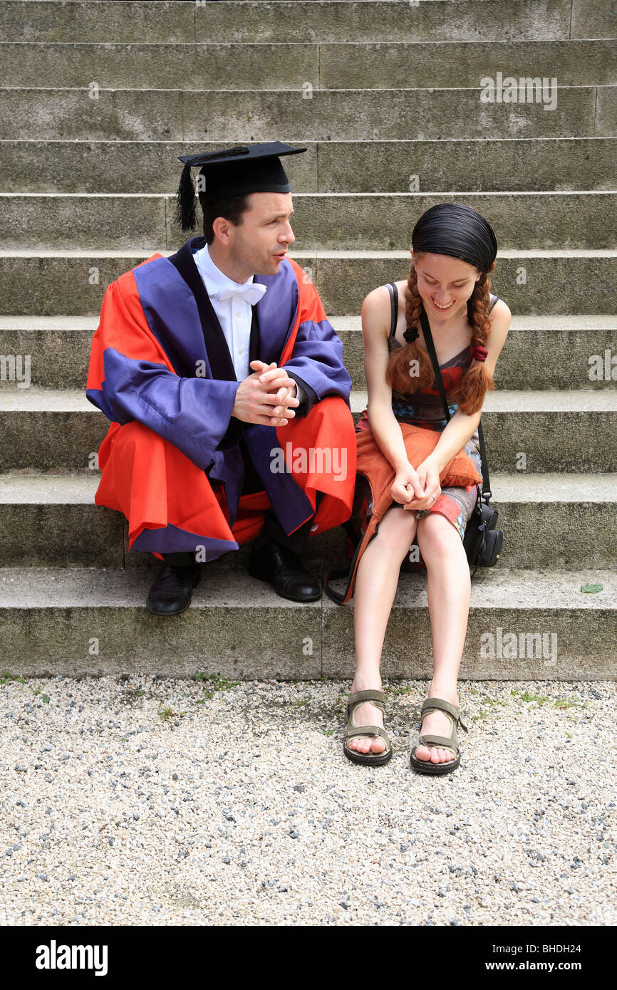 Graduate sitting with his girlfriend on the stairs Stock Photo - Alamy