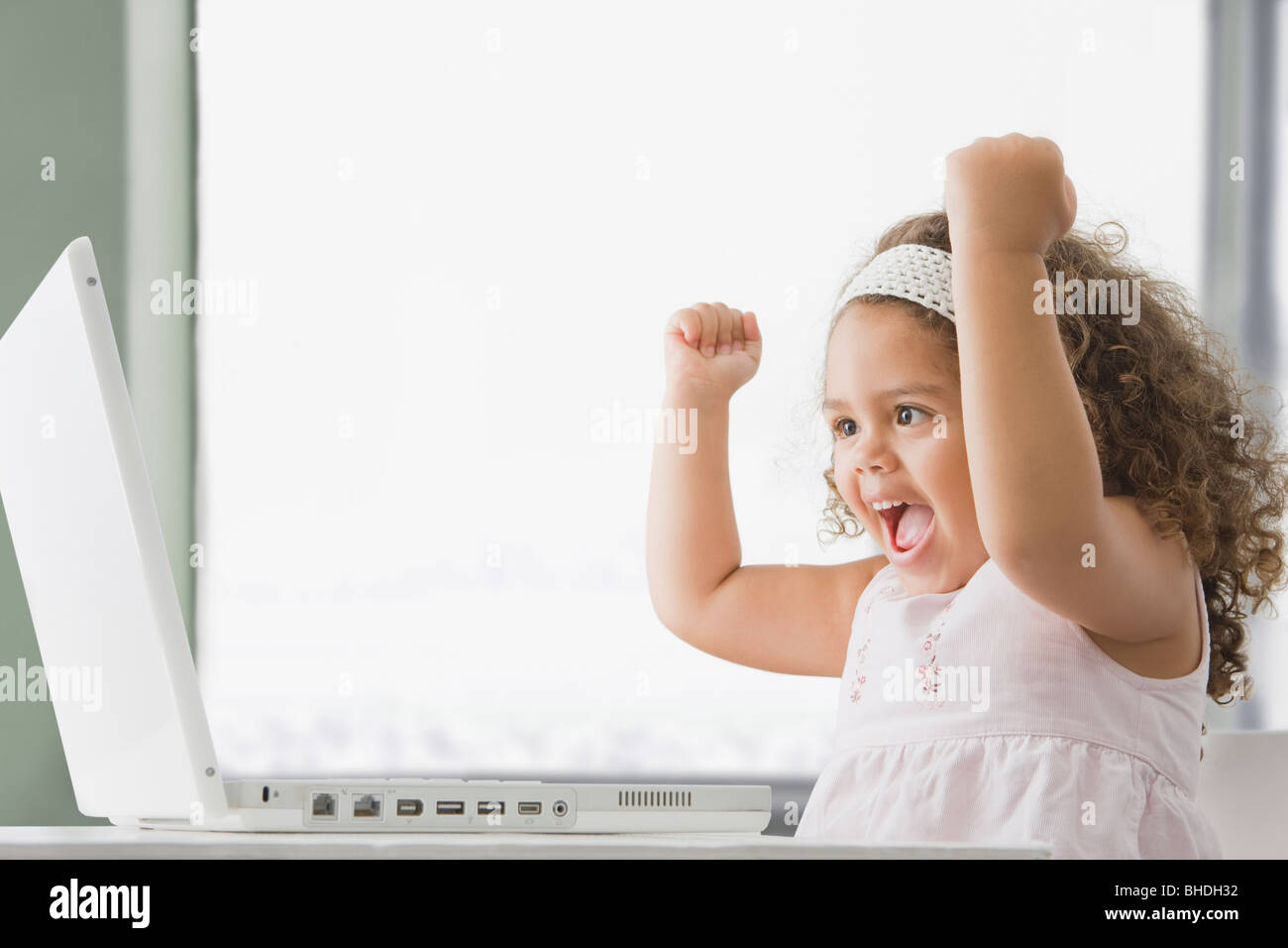 Hispanic girl cheering and using laptop Stock Photo - Alamy