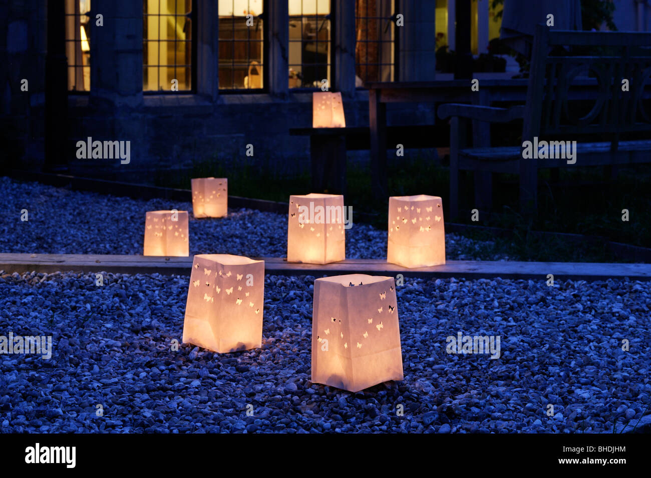 Candle lit lanterns down a gravel pathway at dusk Stock Photo - Alamy
