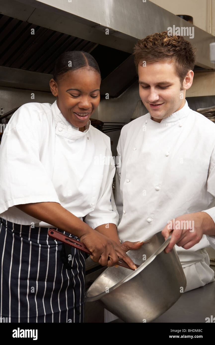Chef Instructing Trainee In Restaurant Kitchen Stock Photo - Alamy