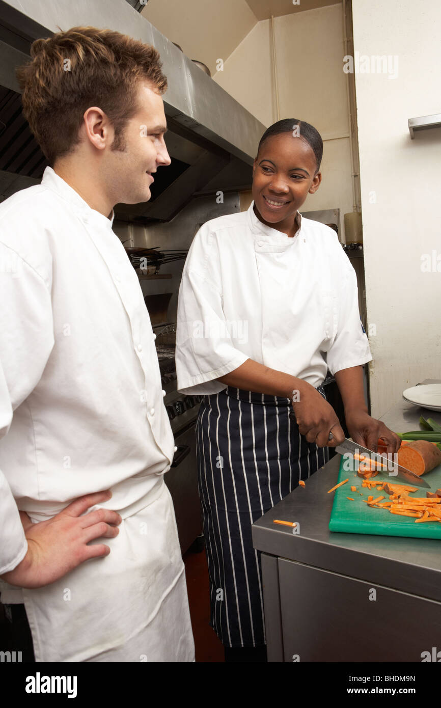 Chef Instructing Trainee In Restaurant Kitchen Stock Photo - Alamy