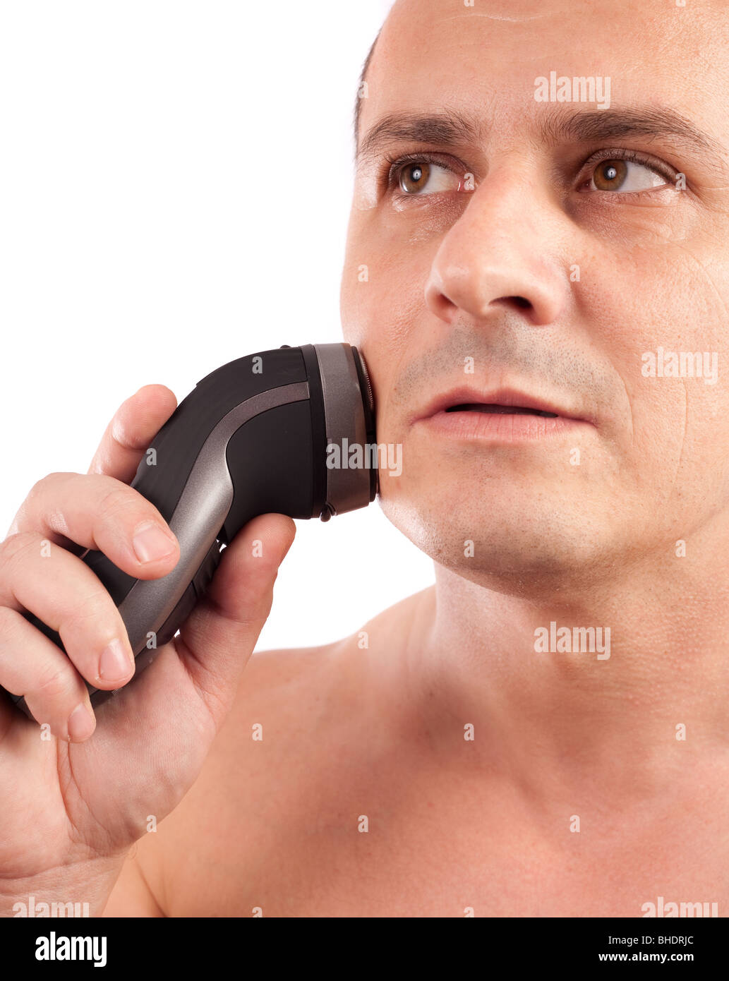 Close up portrait of a handsome young man using an electric shaver ...