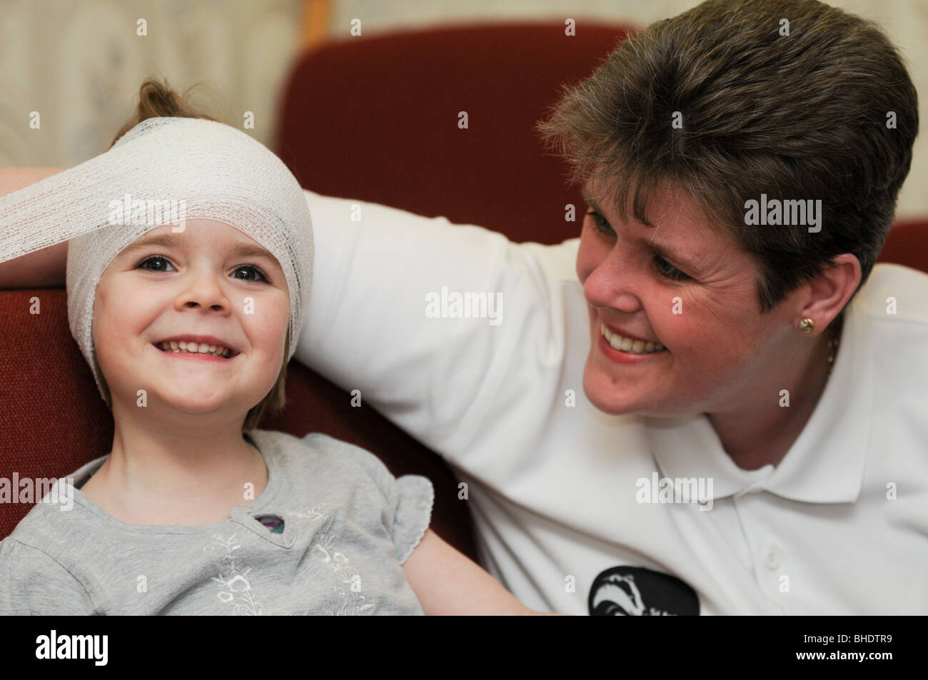 First aid practice being carried out on a little girl who is smiling at ...
