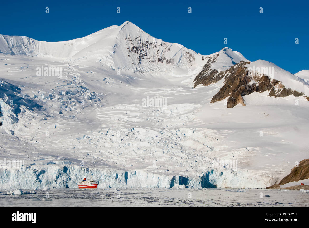 The MS Explorer dwarfed by a giant glacier, in Neko Harbour, Antarctic ...