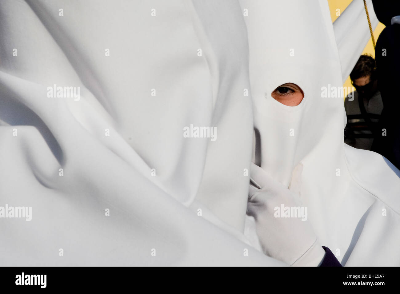 The Holy Week participants wearing a white tunic and a hood with the ...