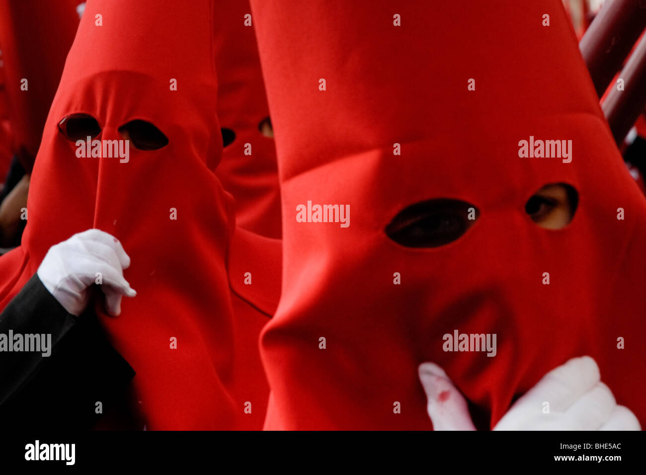 The Holy Week participants wearing a red tunic and a hood with the ...