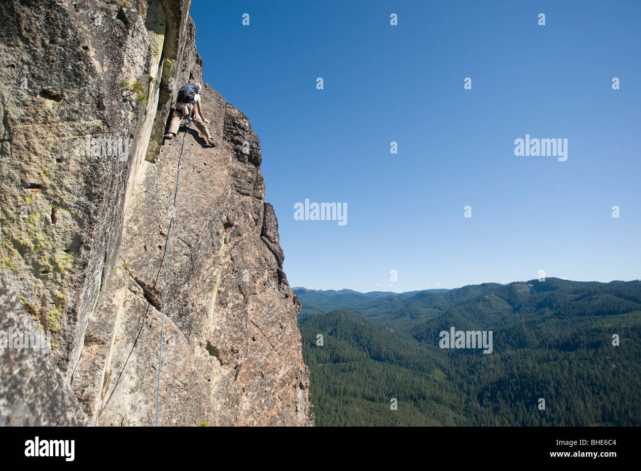 Rock climber climbing a steep face Stock Photo - Alamy